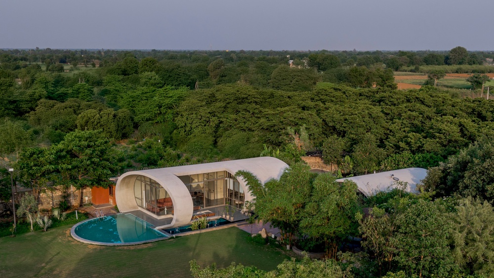 This Ahmedabad house is enclosed within a curved concrete shell
