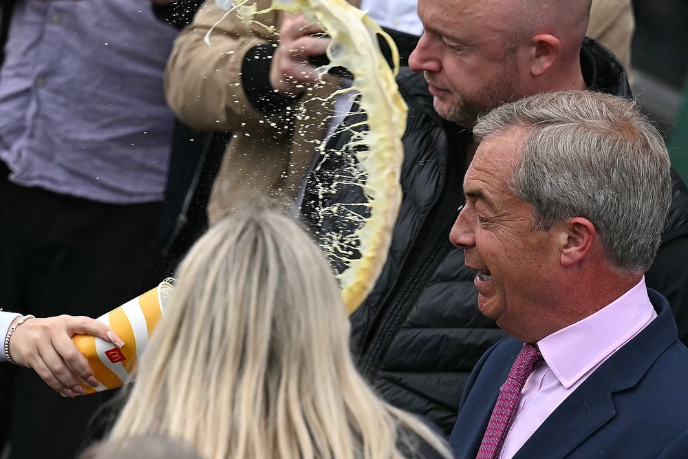 Woman charged after milkshake thrown over Nigel Farage during campaign ...