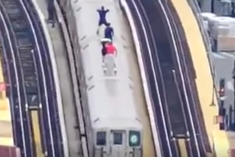Drone footage shows teenagers riding on top of subway train